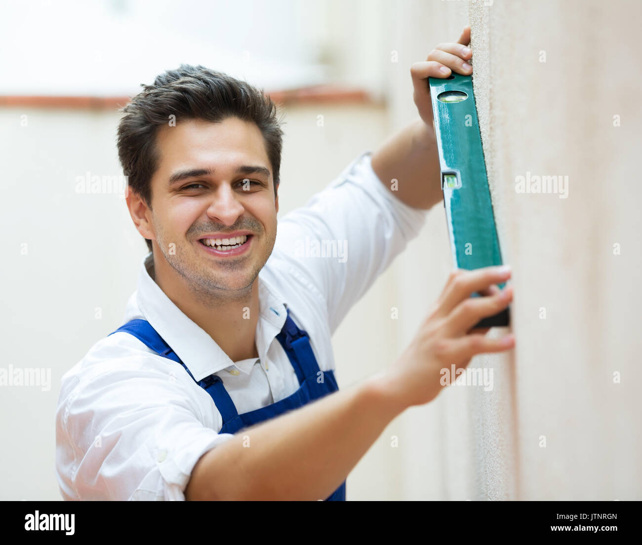 Young specialist making wall plane in new building Stock Photo - Alamy