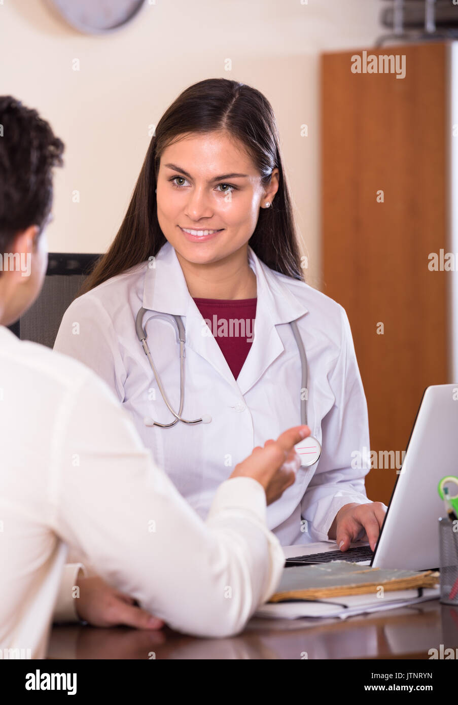 Positive doctor receiving ill patient at cabinet and questioning Stock ...