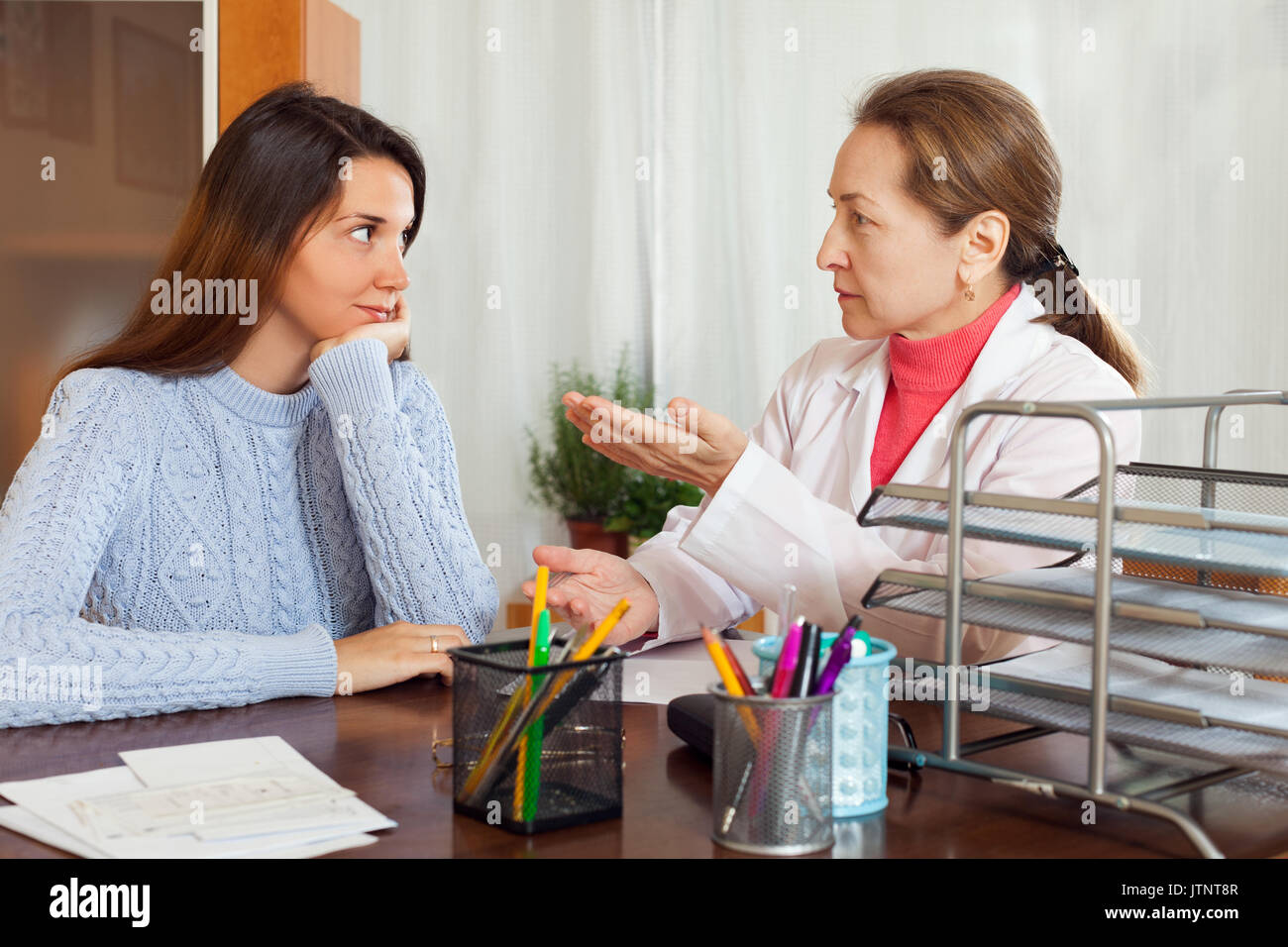 Female teenager patient listening the doctor about medicine at table ...
