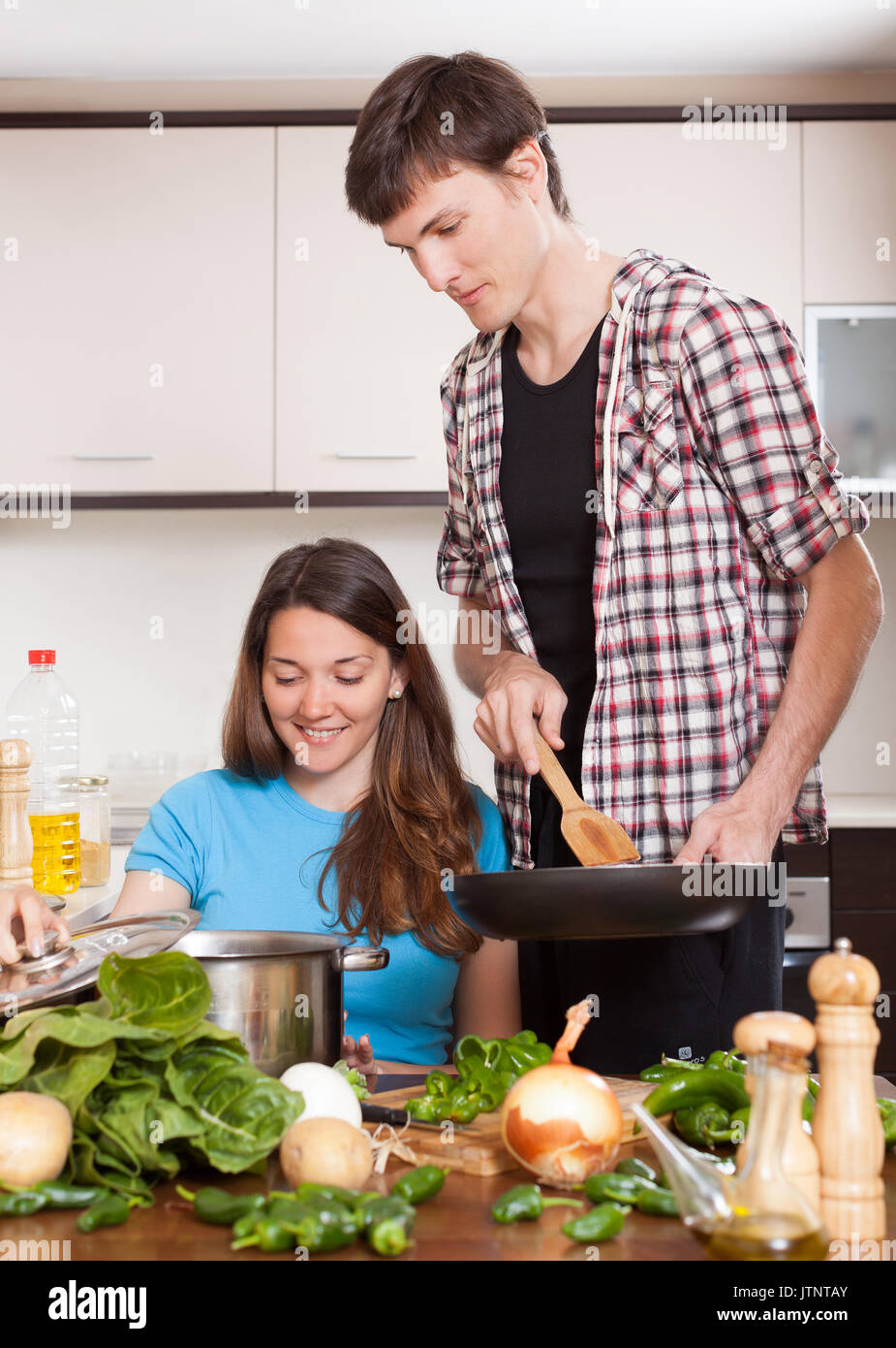 Guy and pretty girl together cooking Stock Photo - Alamy