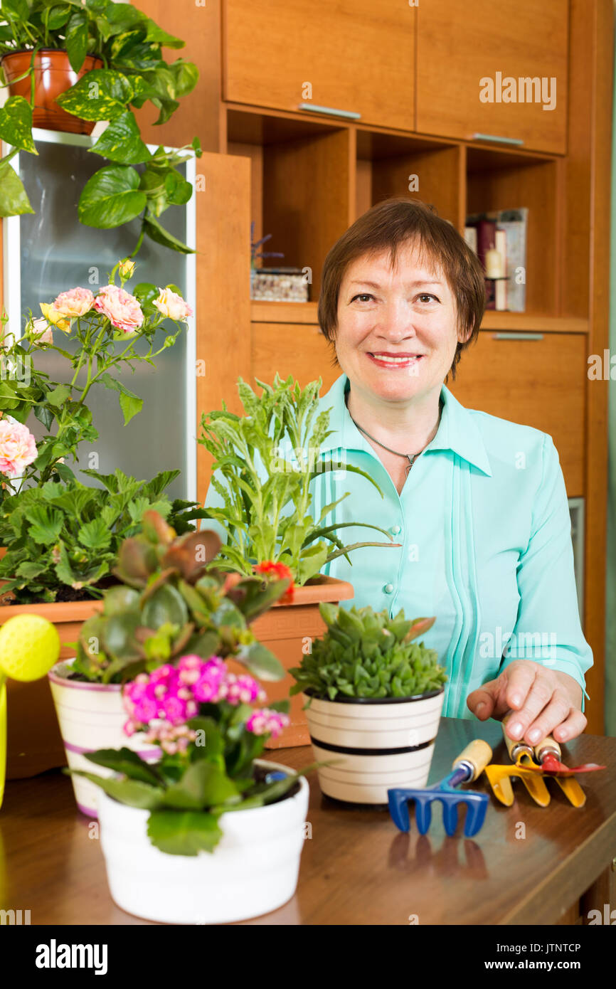 Happy mature gardener with flowerpots at home Stock Photo - Alamy