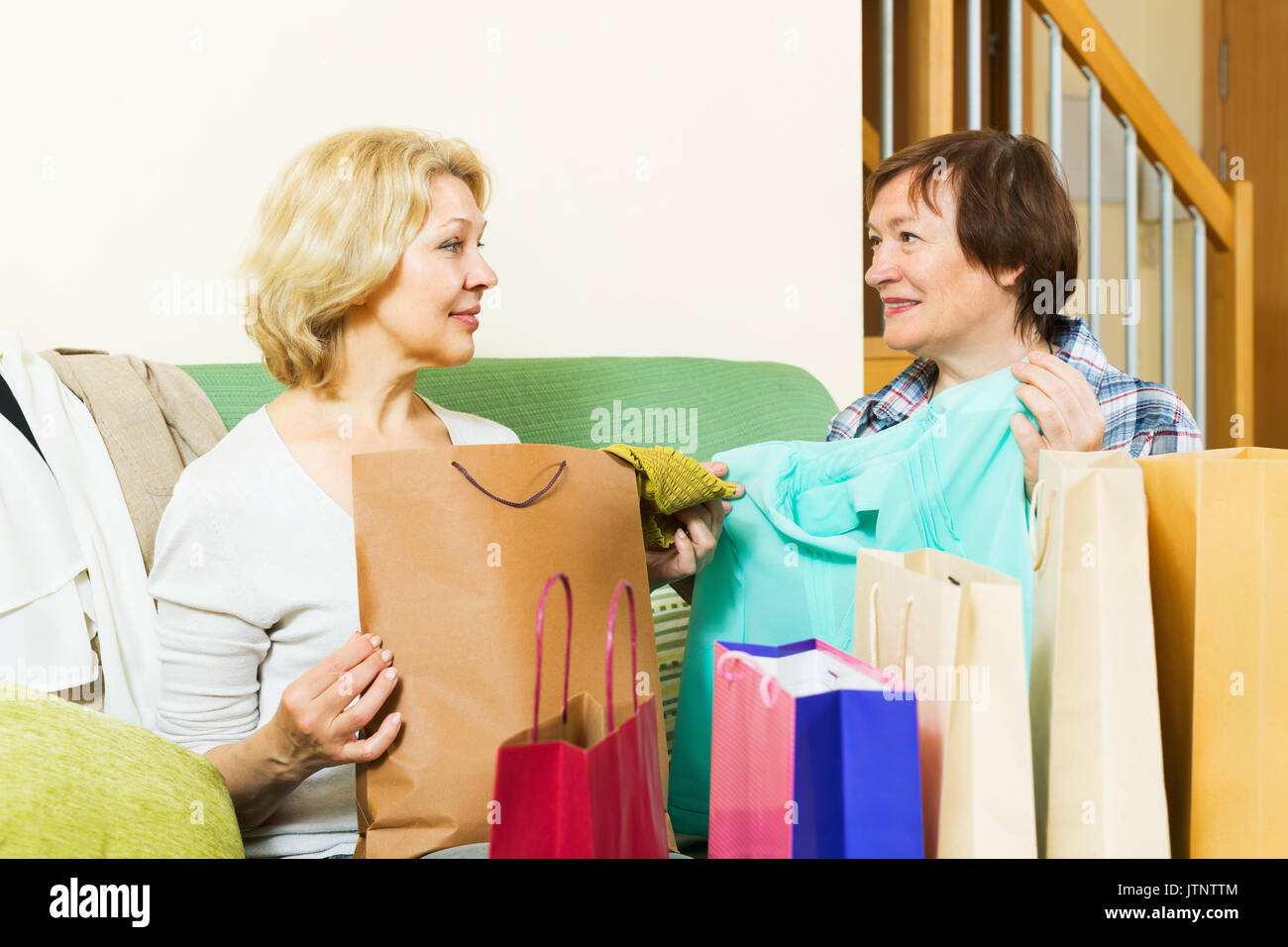 Happy pensioner bragging with new blouse in front of friend Stock Photo ...