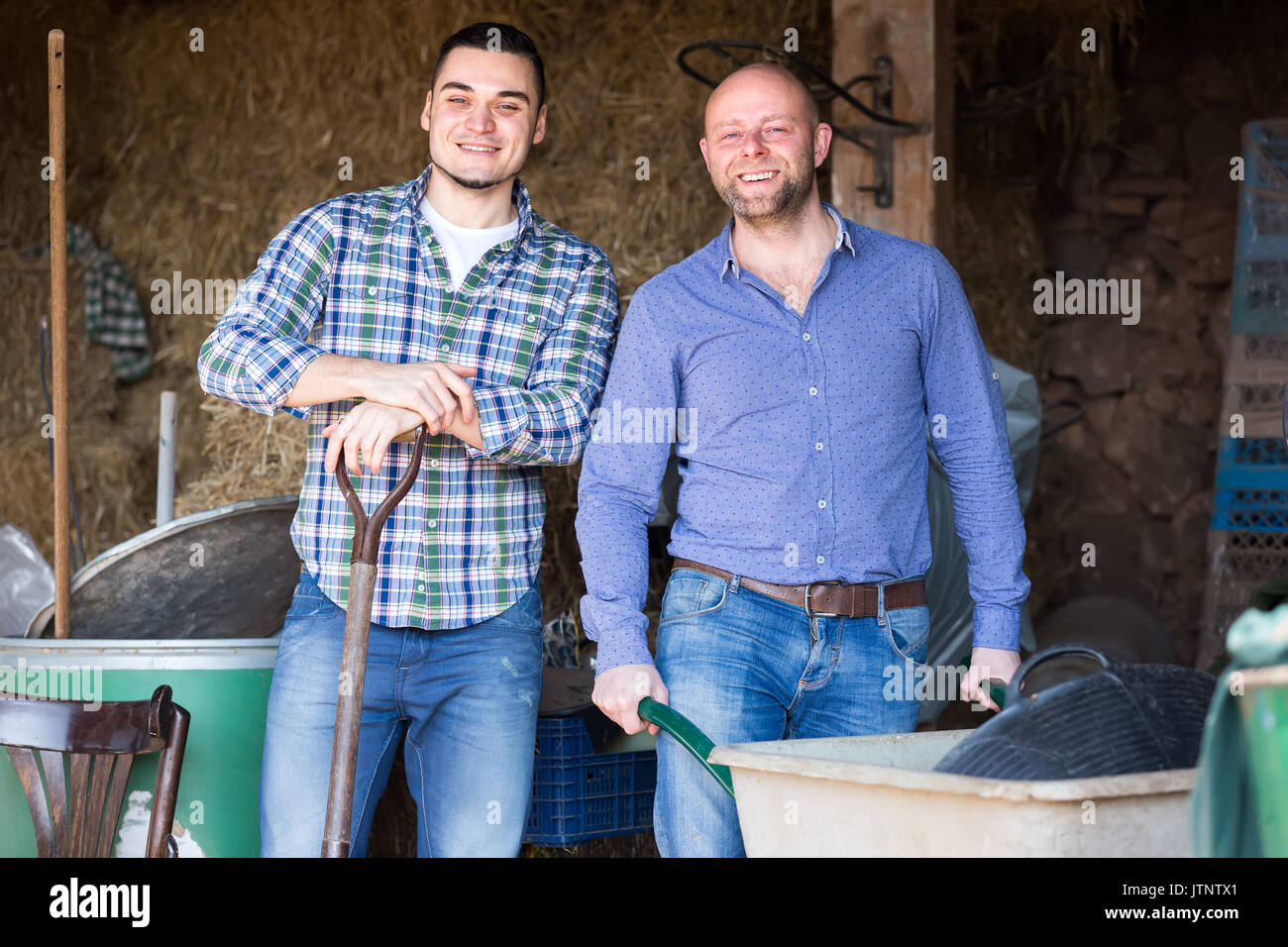 Two men working on a farm in shed Stock Photo - Alamy
