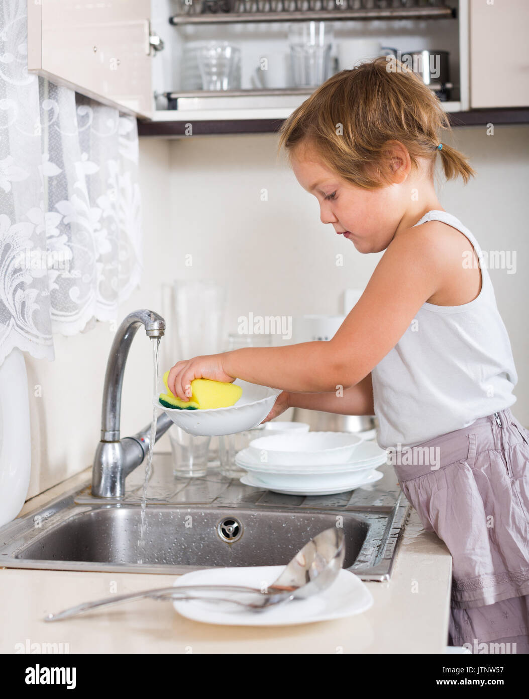 little girl washing dishes in the kitchen Stock Photo - Alamy