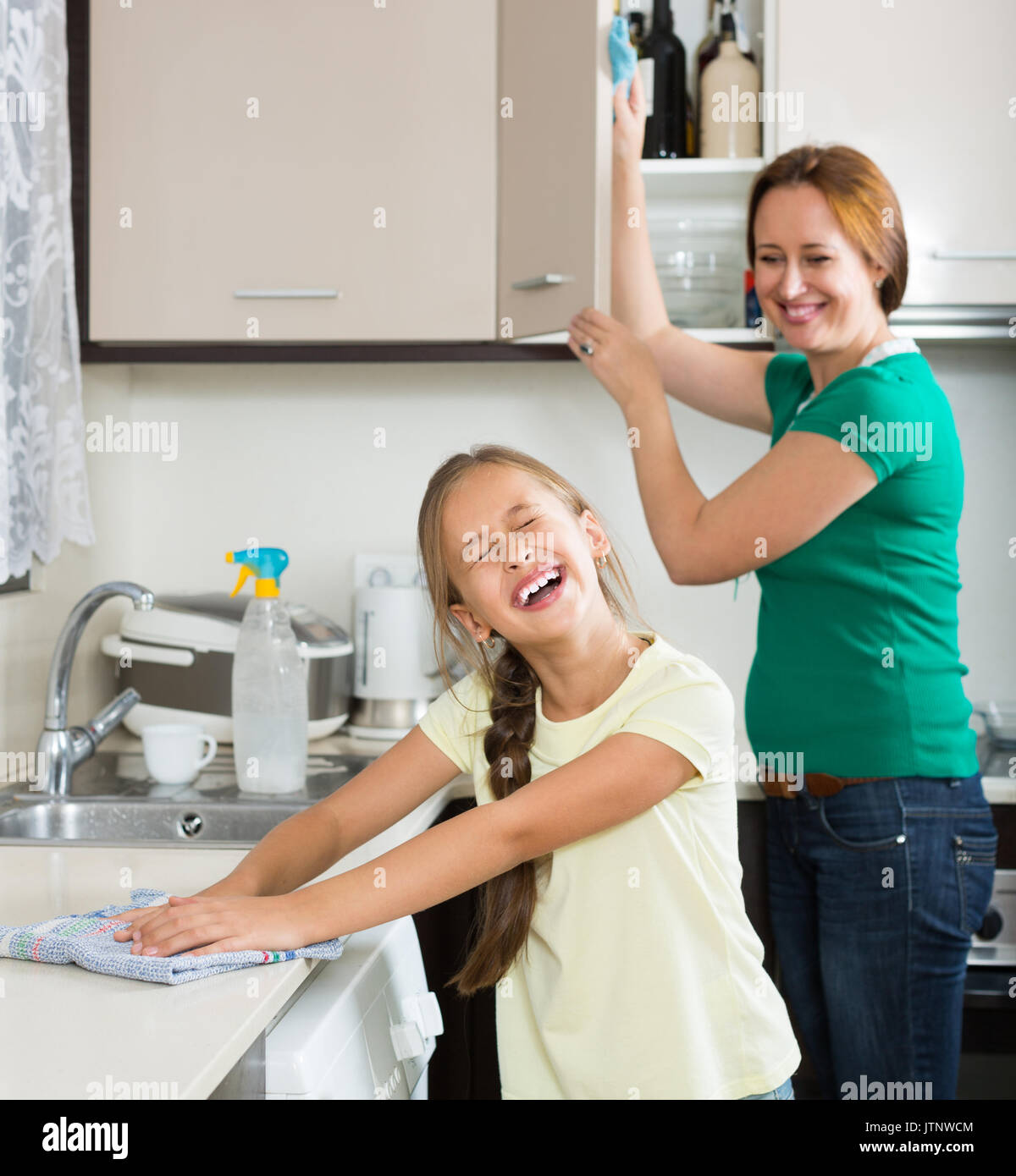 Daughter helping smiling mother clean hi-res stock photography and ...