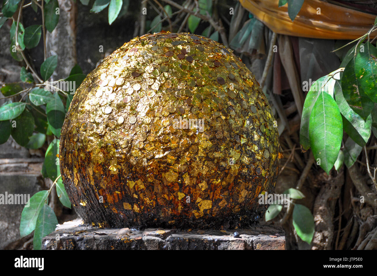 A golden sphere covered in gold leaves, in a Buddhist temple in ...