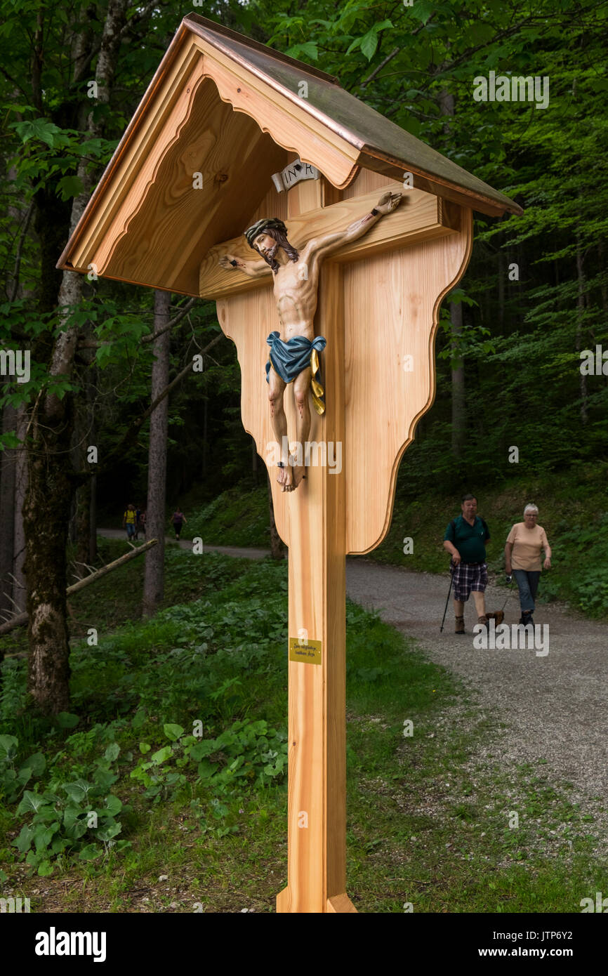 Carved wooden Jesus on the crucifix in a wood shelter by the path ...