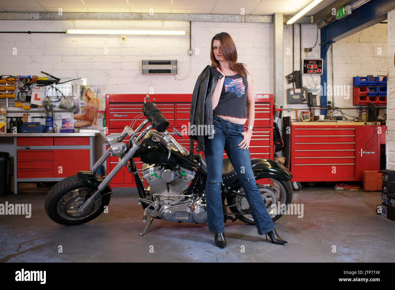 Beautiful girl and a custom built chopper motorcycle in a garage ...