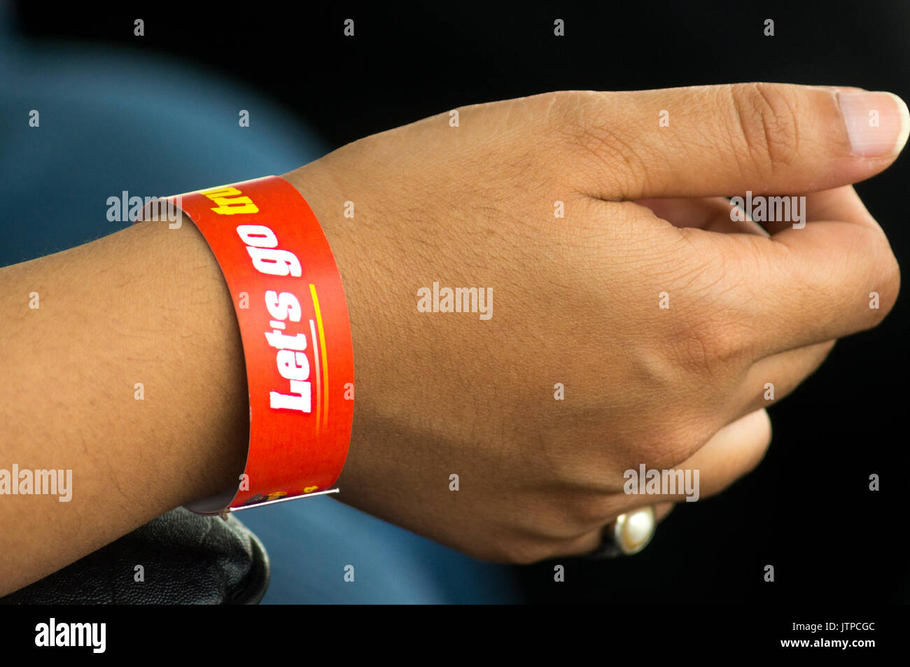 Dark skinned man with an inspirational wrist band given during a racing ...