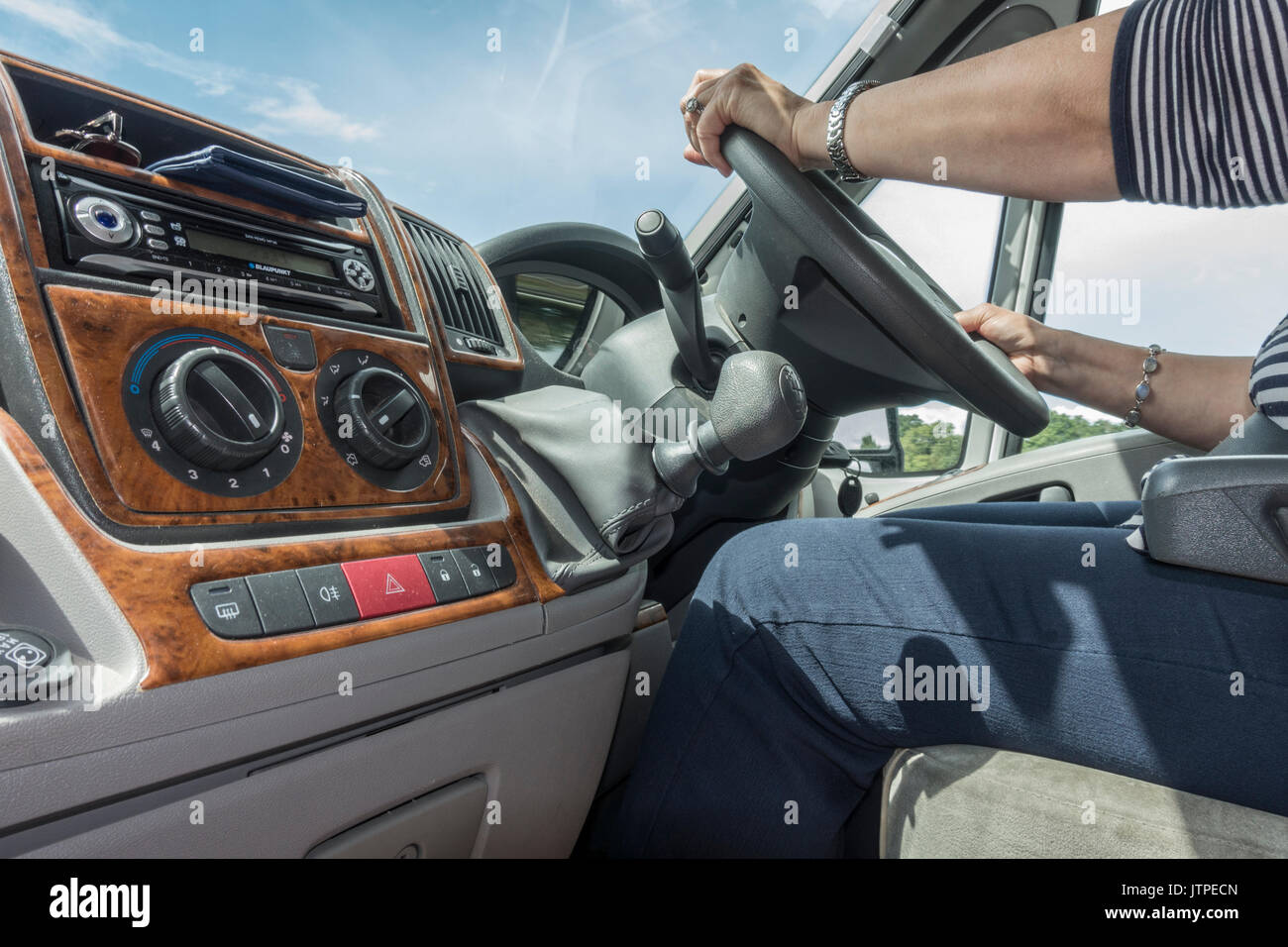 Cab view of a woman driving a motorhome in England, UK. Right hand ...