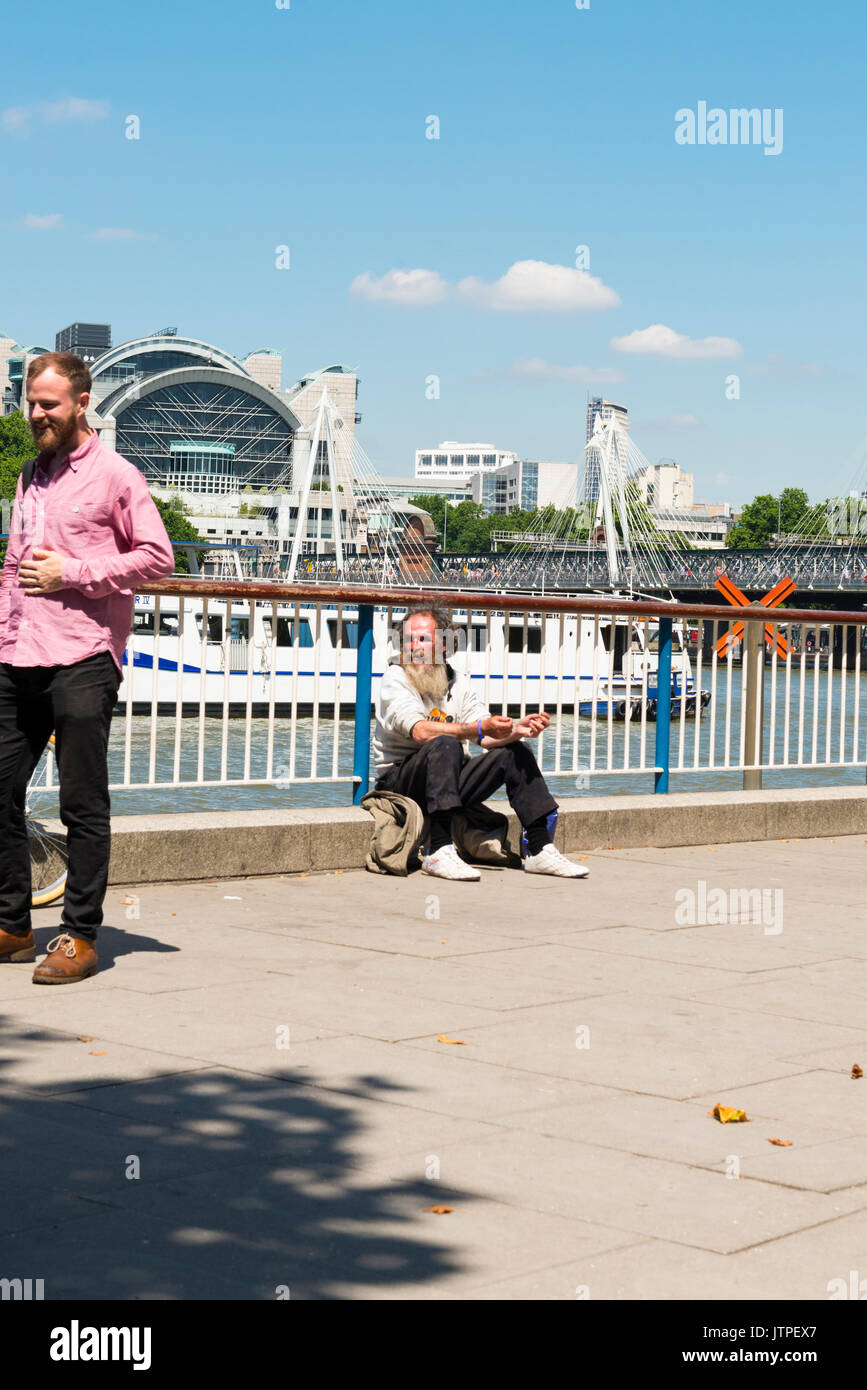 UK London Southbank scruffy dirty male man long hair beard sitting ...