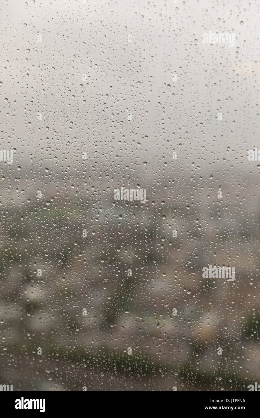 Grey Rainy day in London view through high rise window with rain drops ...
