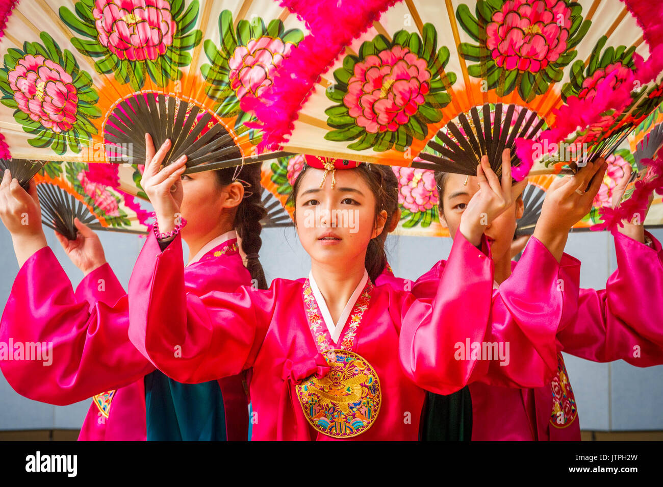 Female Korean dancers hold up giant fans during fan dance performance ...