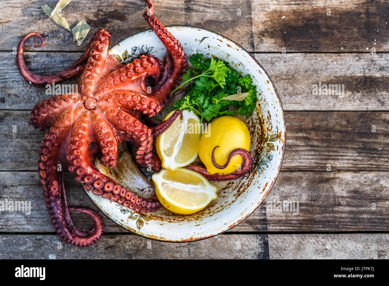 Big boiled octopus with lemon and parsley, rustic style, top view Stock ...