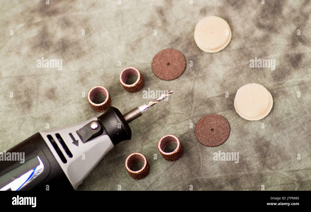 A gray drill with drilling accessories on gray background, above view ...