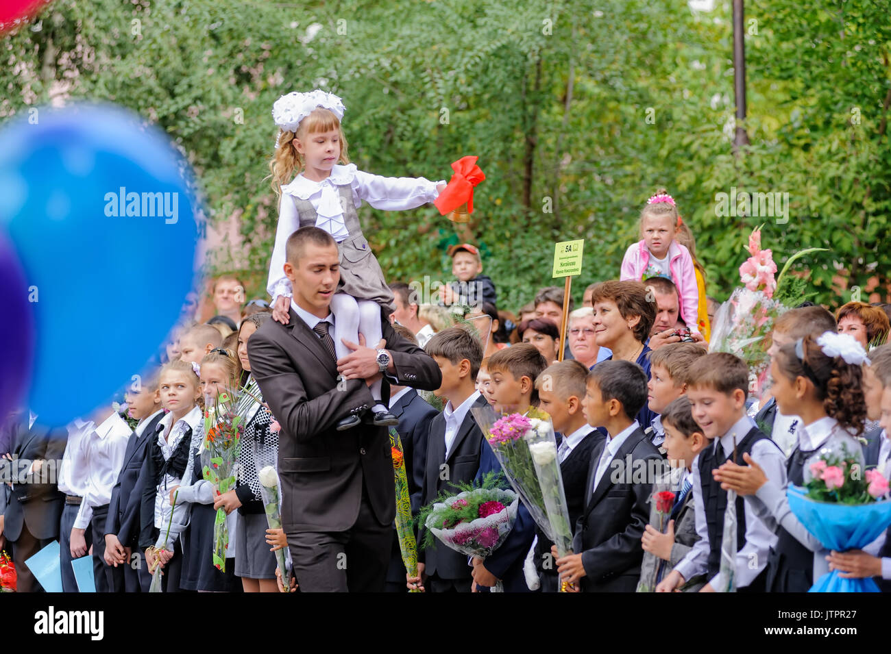 Girl ringing bell for first-graders - first bell Stock Photo - Alamy