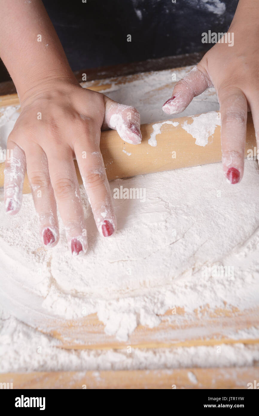 Close-up of woman rolling dough with rolling pin. Cooking concept Stock ...