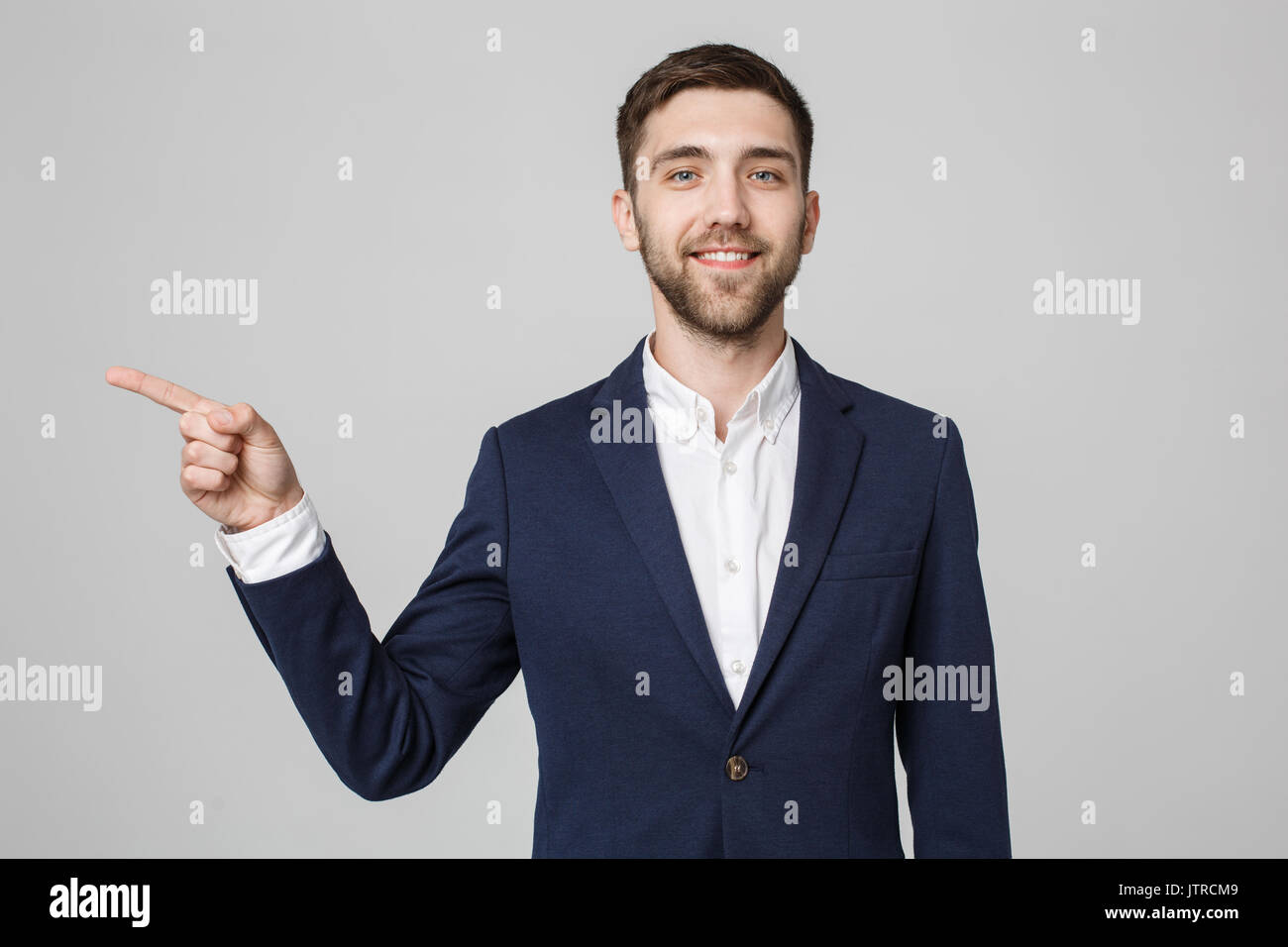 Young successful businessman pointing direction with finger over dark ...