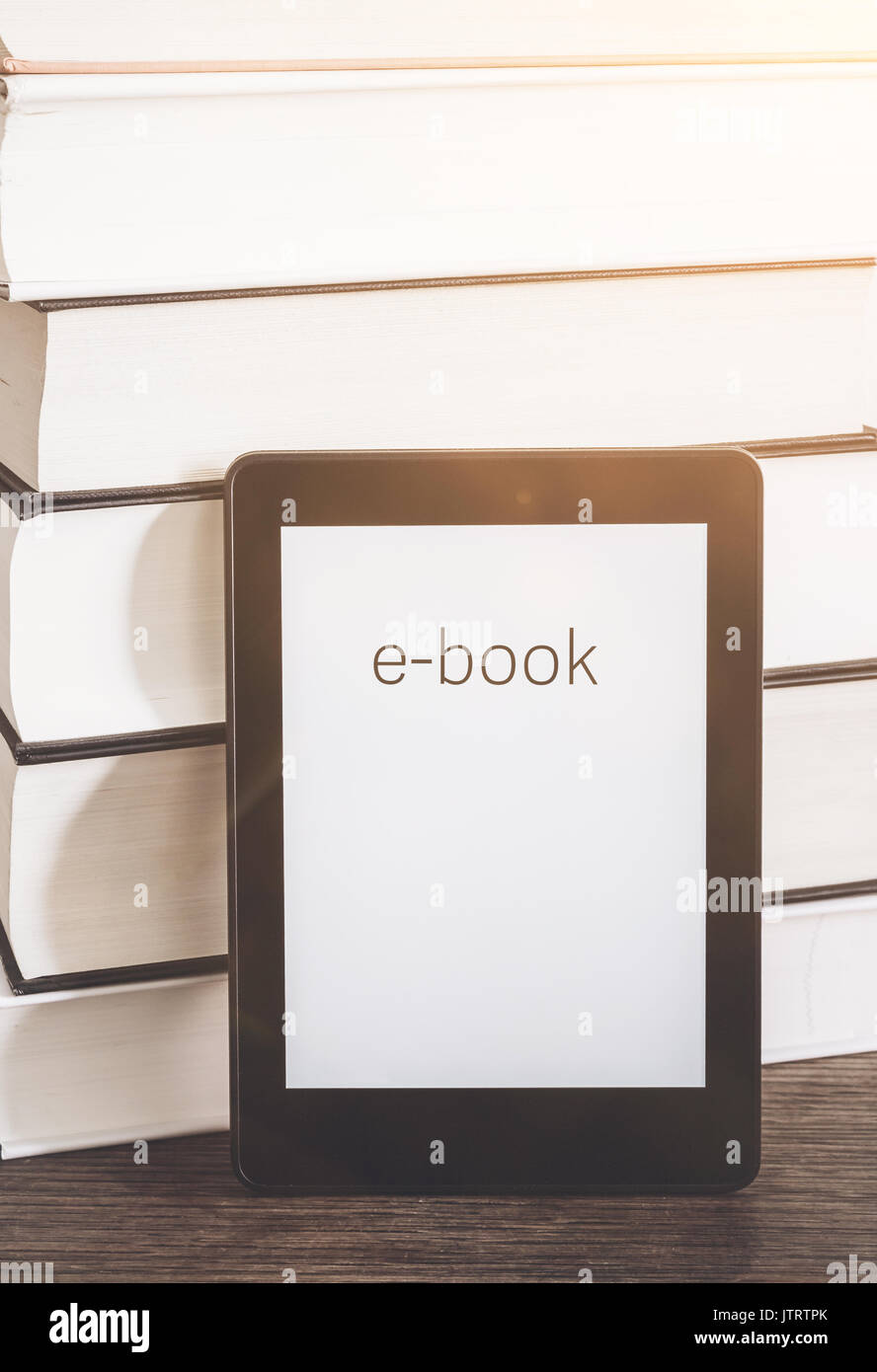 e-book reader on a stack of books on rustic wooden table concept Stock ...