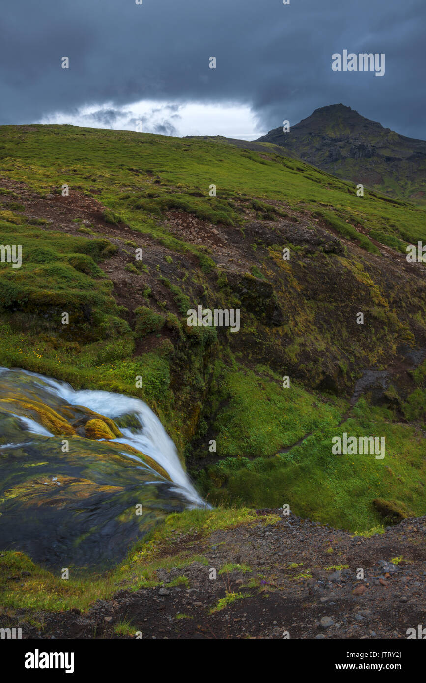 A small waterfall amid the dramatic, volcanic, sub alpine landscape of ...