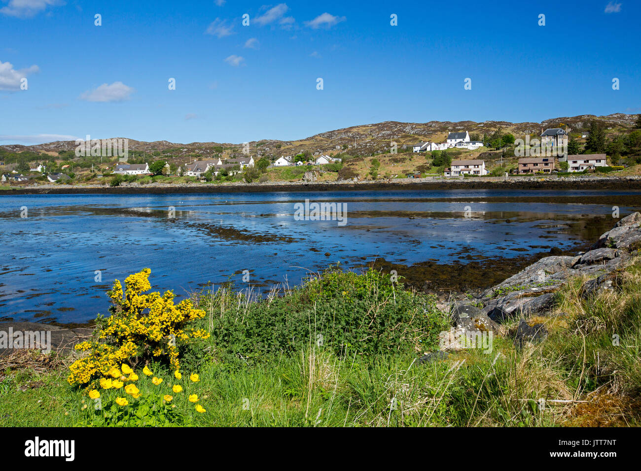 Panoramic view of houses on hillside overlooking blue water of Loch ...