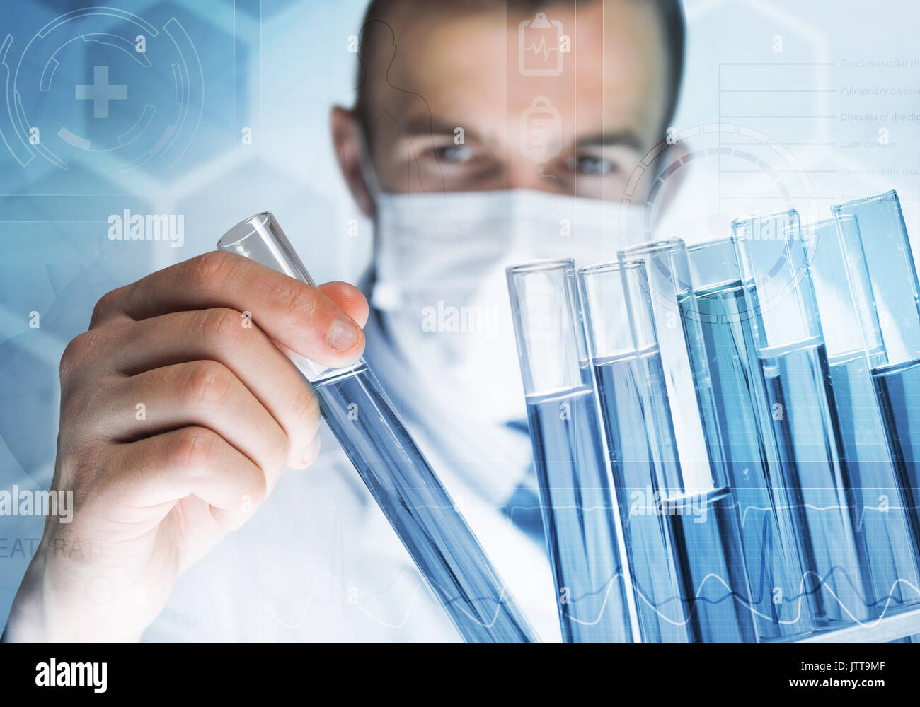 Young scientist mixing reagents in glass flask in clinical laboratory ...