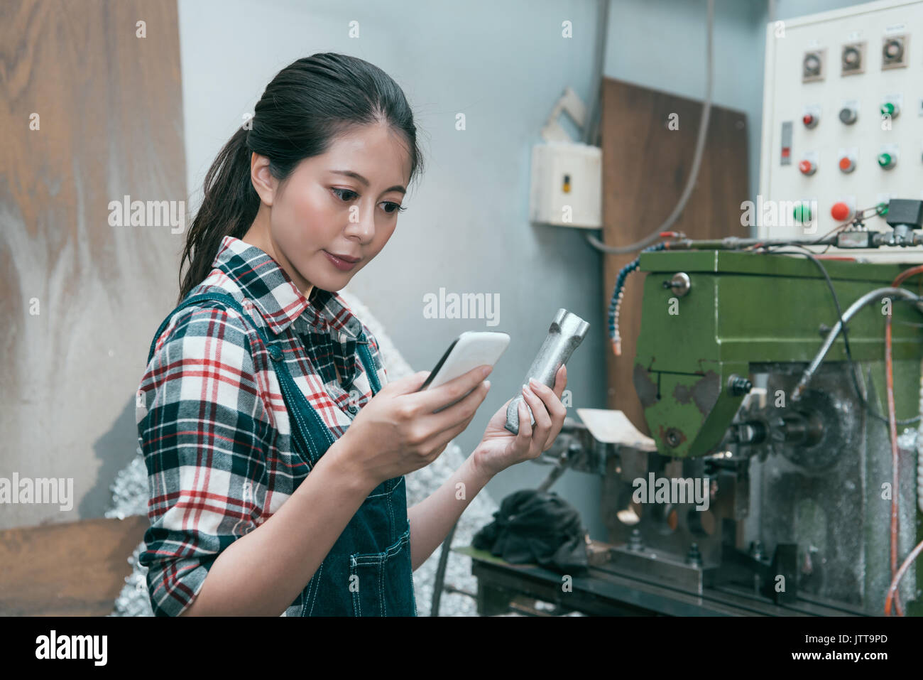 attractive young lathe factory female worker checking milling machining ...