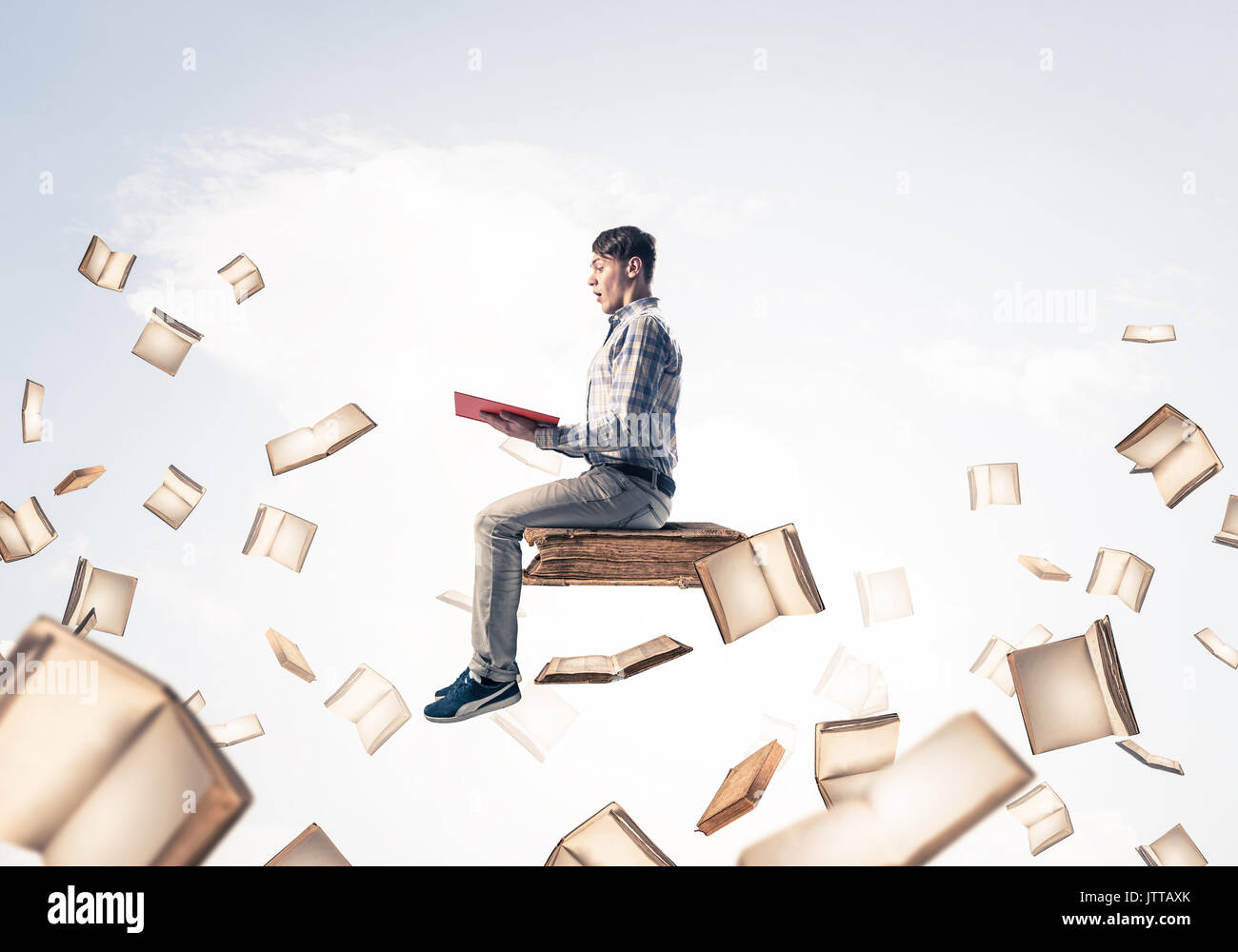 Man reading book and many of them flying in air Stock Photo - Alamy