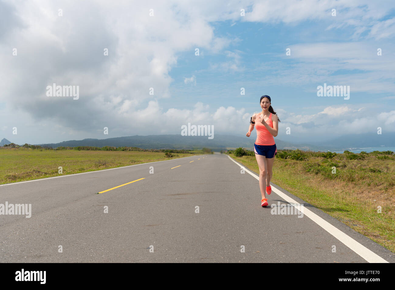 young woman in the beautiful scenery road jogging running workout ...