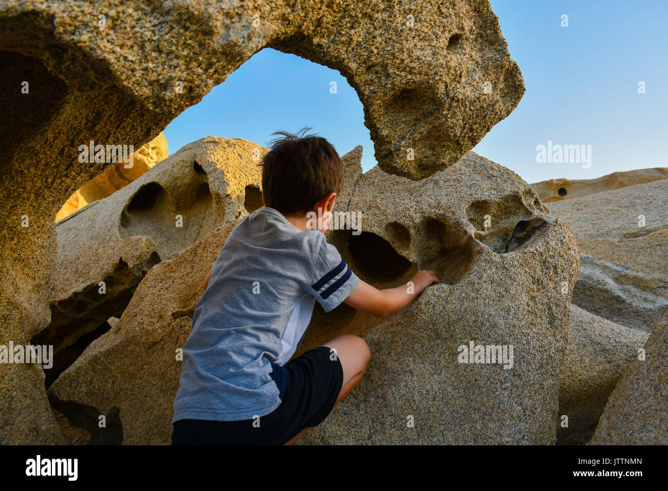 Boy on rocks Stock Photo - Alamy