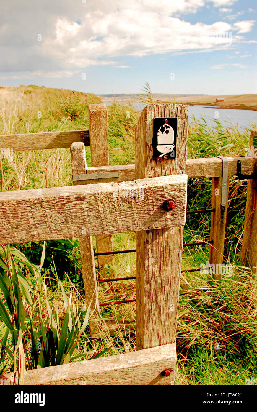 An acorn sign on a 'kissing gate', denoting the South West Coast Path ...