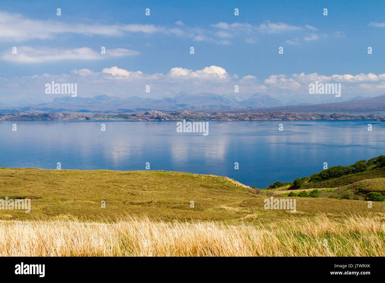 View from Isle of Skye across tranquil blue ocean to mainland and ...