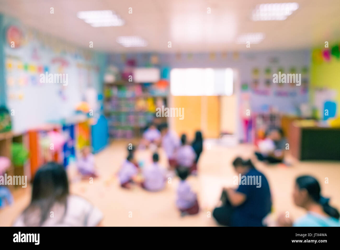 Blur image of student, parent and teacher in kindergarten classroom ...