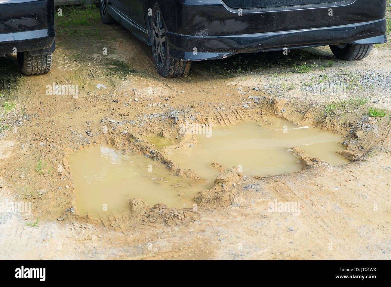 Wheel track in mire or car mired, rut fragment mired in mud in car park ...