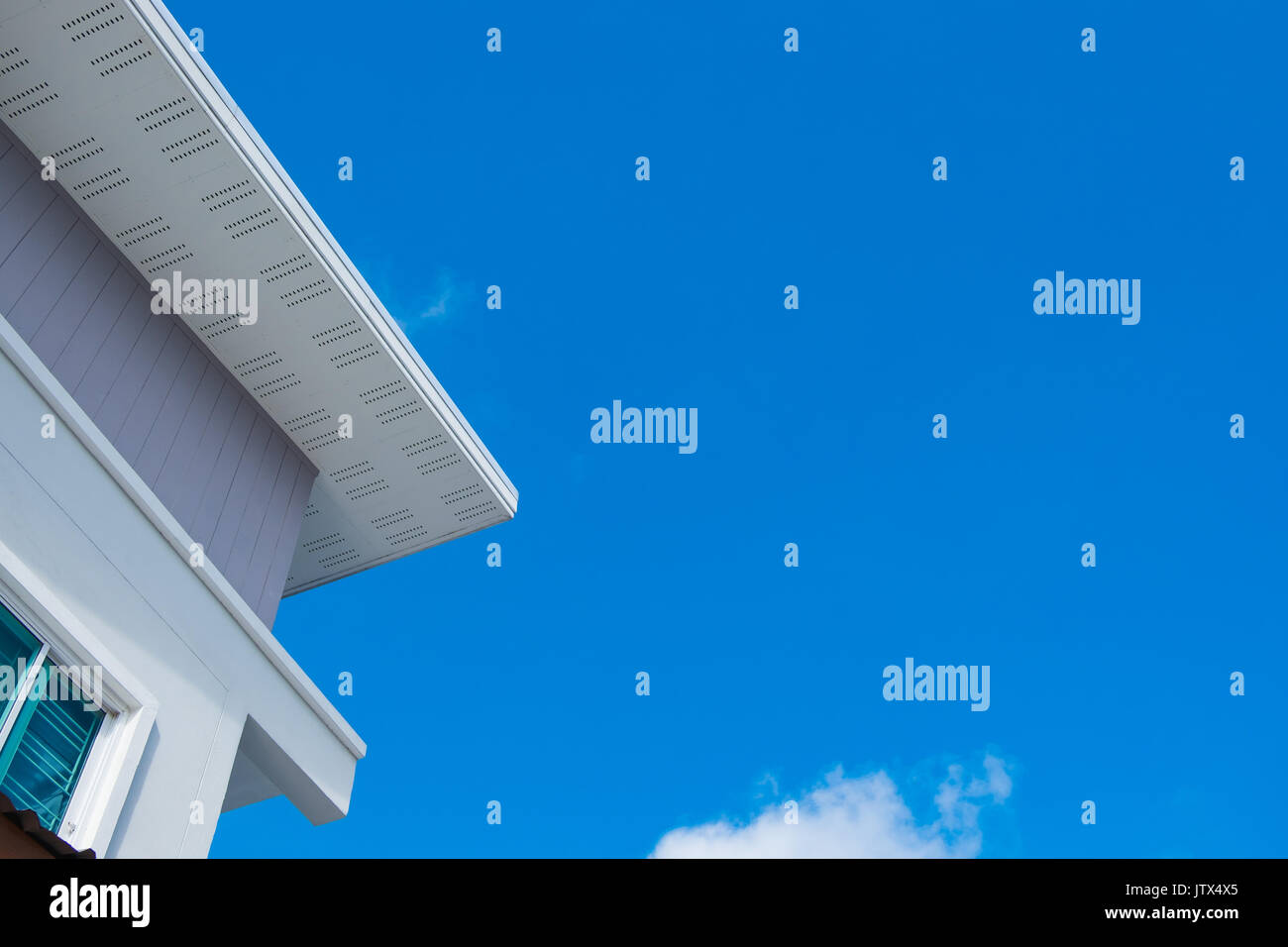 White eaves with ceiling and roof of modern house against blue sky ...
