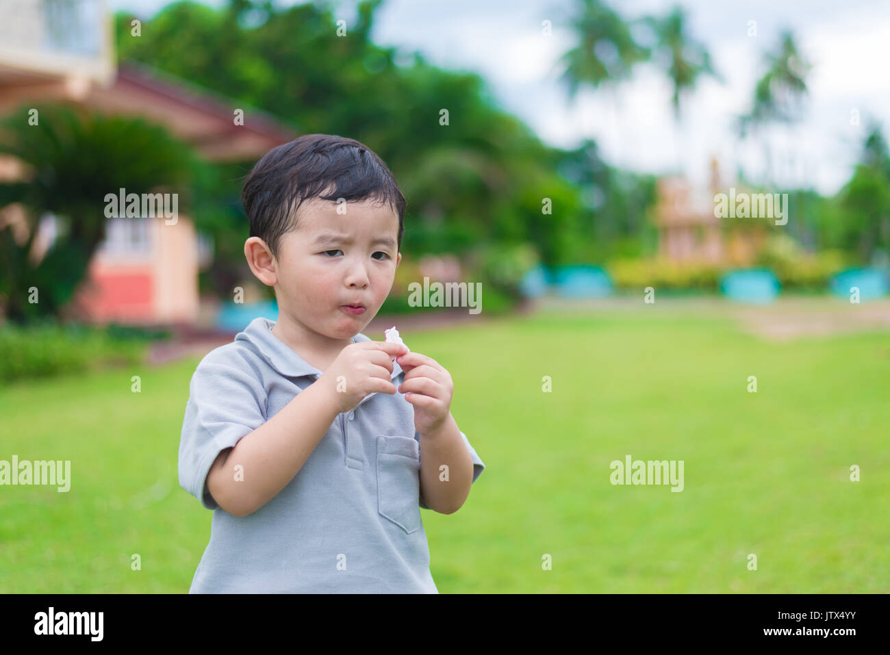 Little Asian kid at the playground under the sunlight in summer ...
