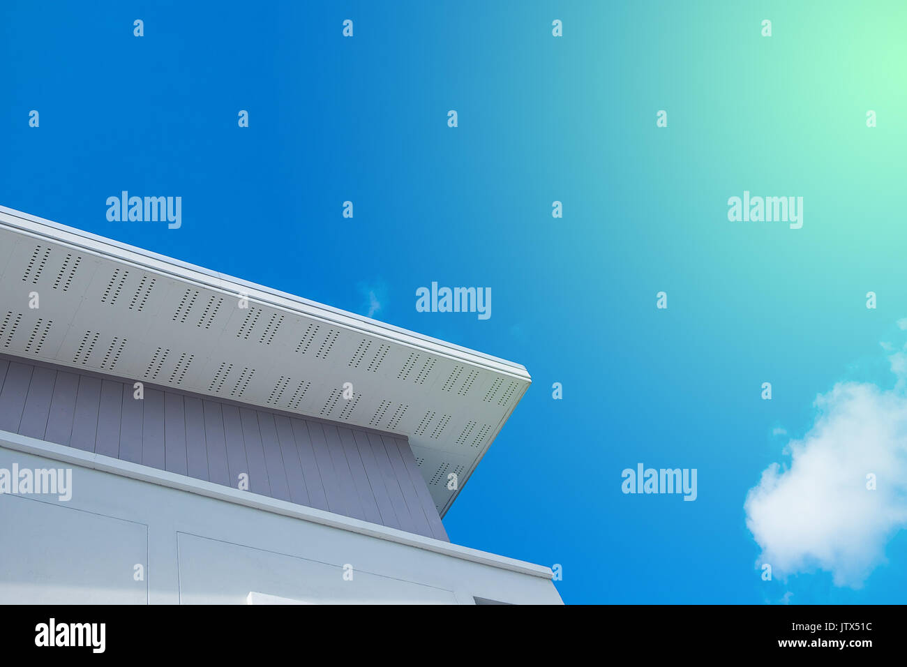 White eaves with ceiling and roof of modern house against blue sky ...