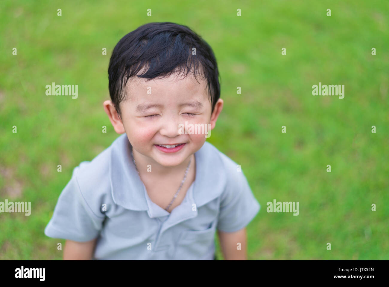 Little Asian kid at the playground under the sunlight in summer ...