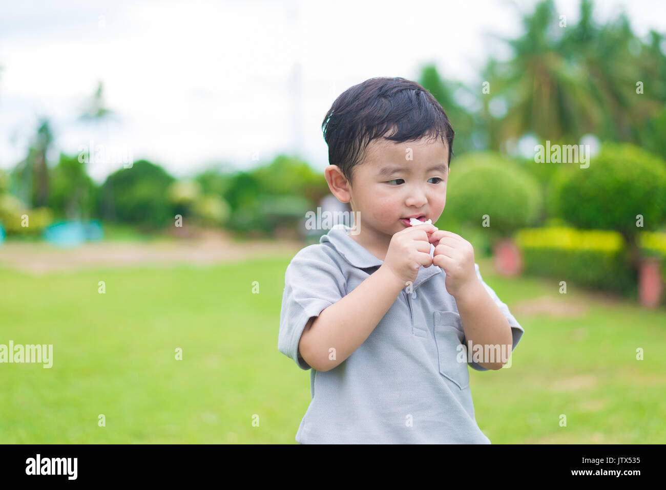 Little Asian kid at the playground under the sunlight in summer ...