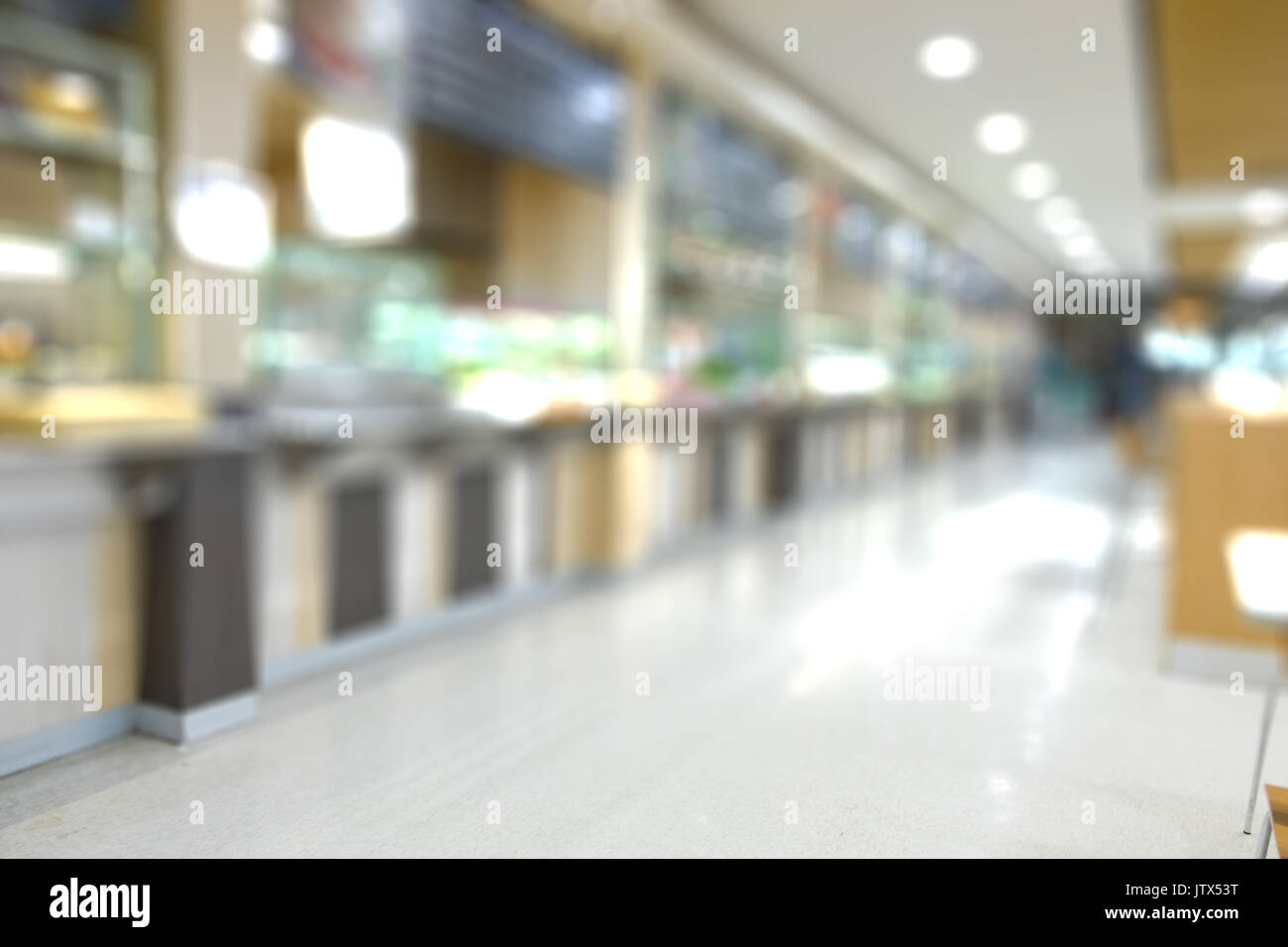Blur of white table and wooden table on food court in shopping mall ...