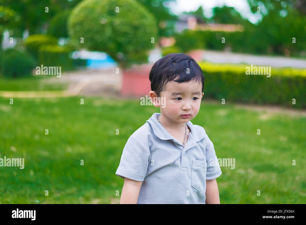Little Asian kid at the playground under the sunlight in summer ...