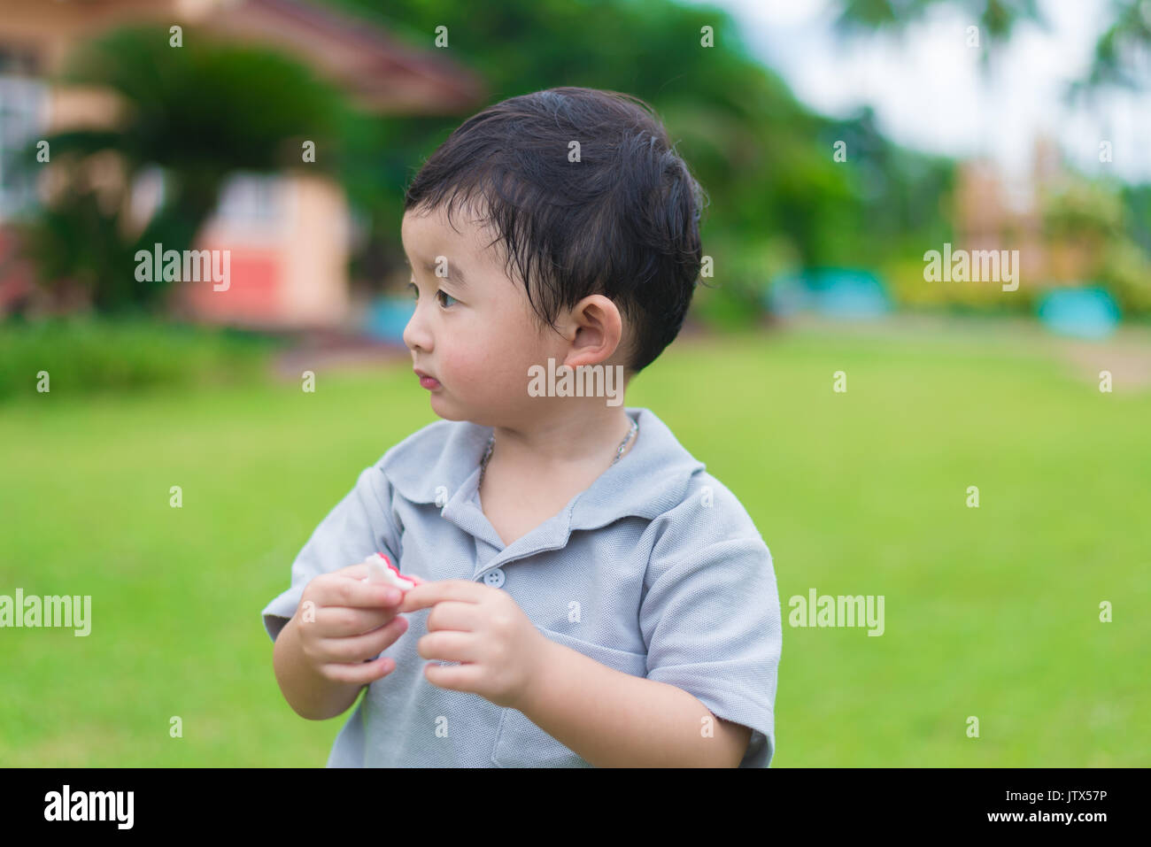 Little Asian kid at the playground under the sunlight in summer ...