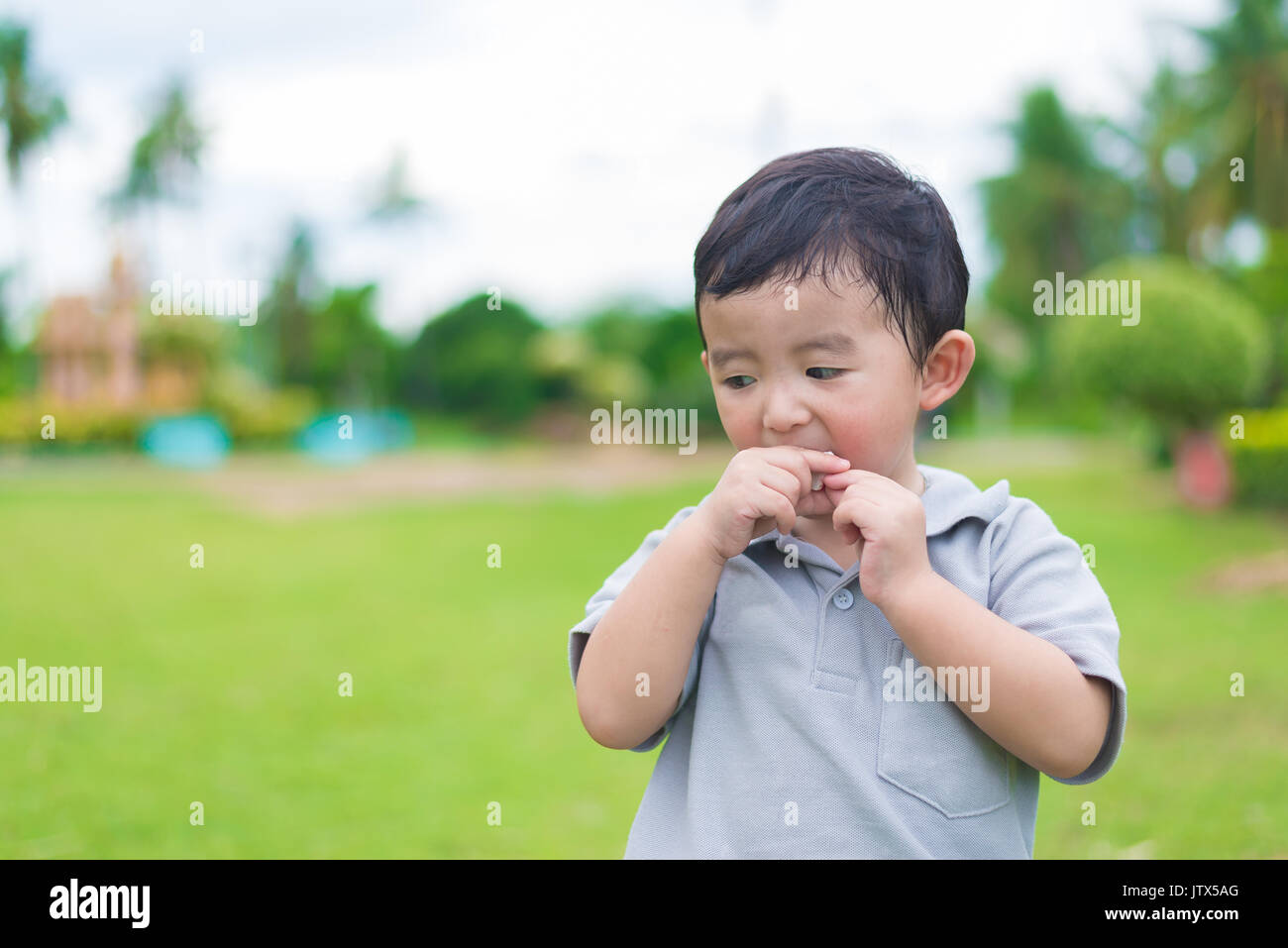 Little Asian kid at the playground under the sunlight in summer ...
