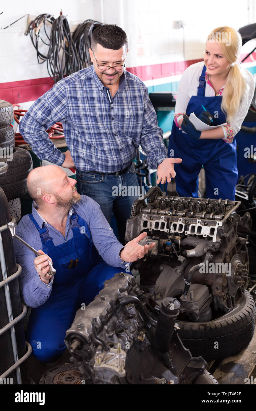 Team of mechanics repairing engines in a workshop Stock Photo - Alamy