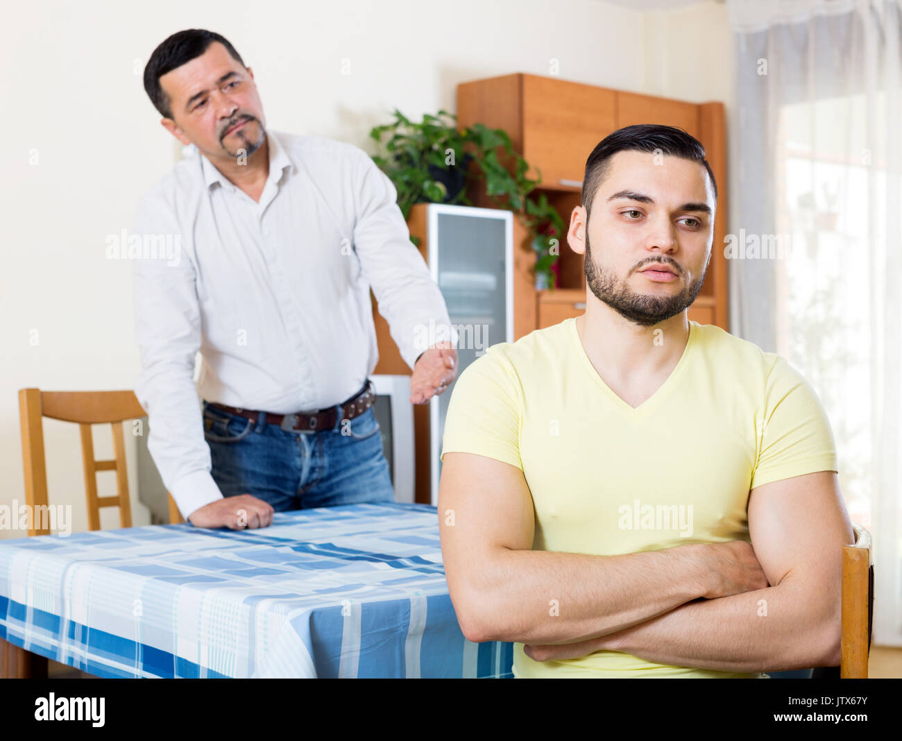 Domestic quarrel between mature father and young son Stock Photo - Alamy