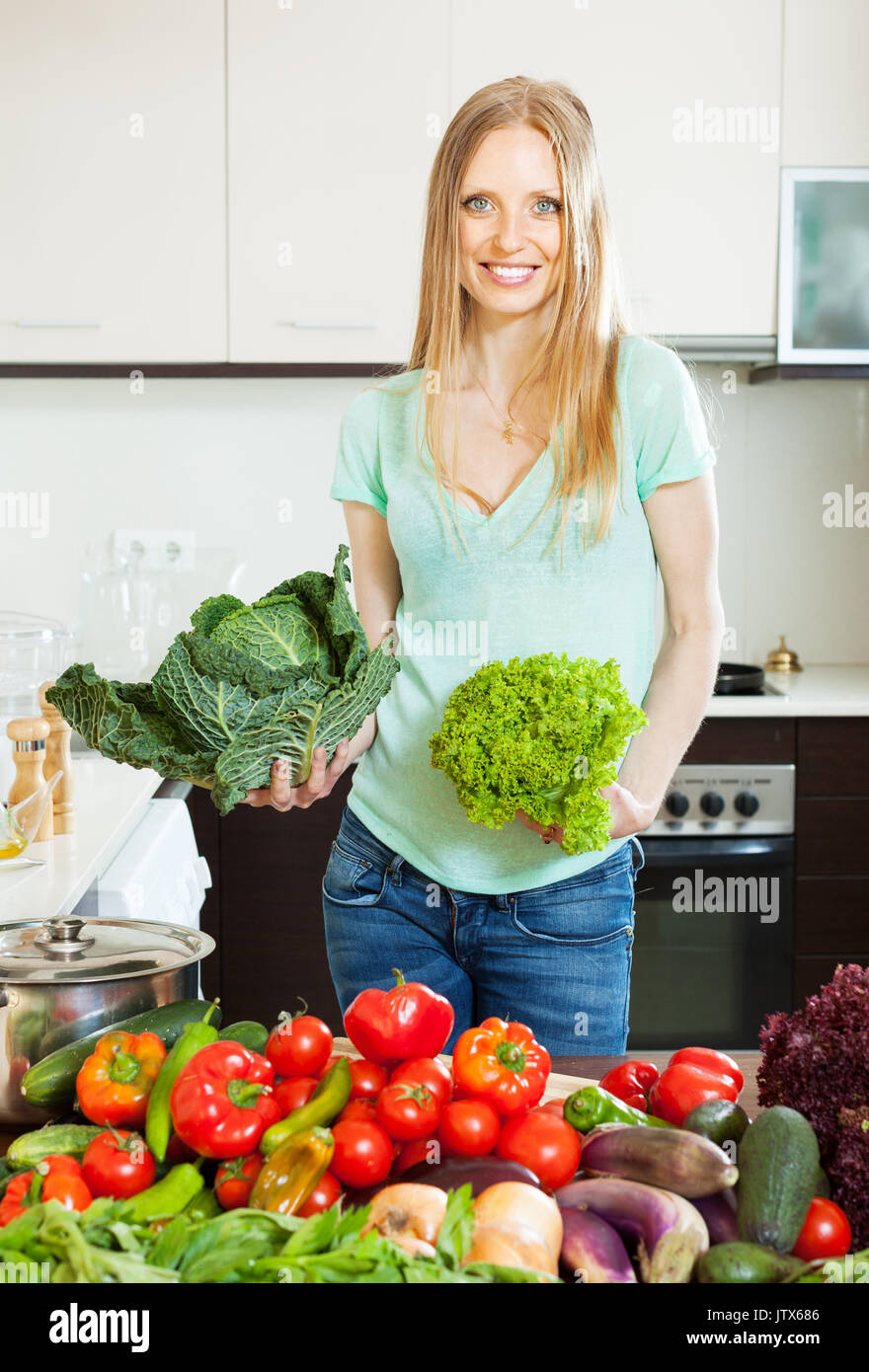 Blonde beautiful housewife cooking with fresh vegetables at home Stock ...