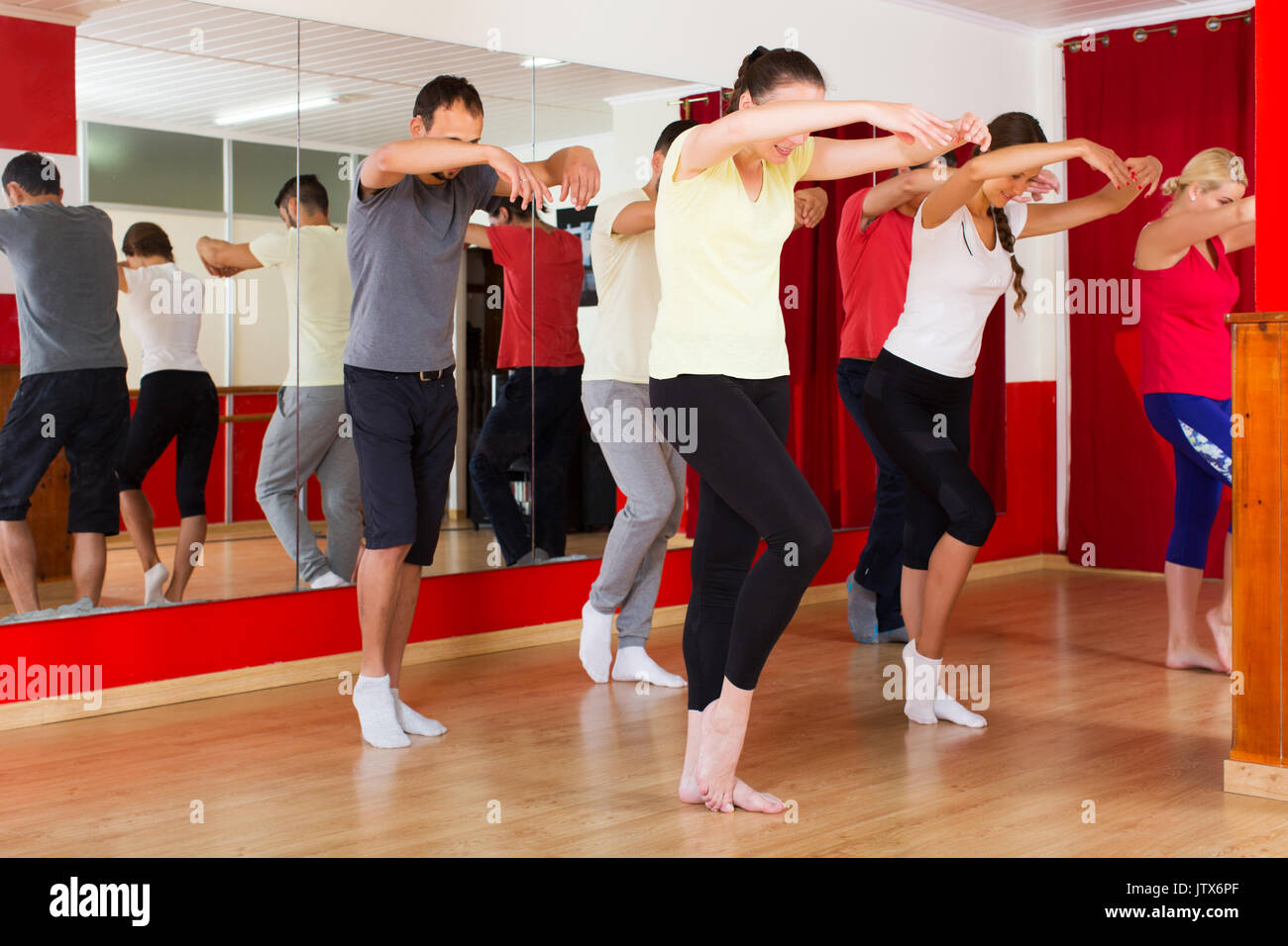 Active smiling couples dancing modern style dance in class Stock Photo ...