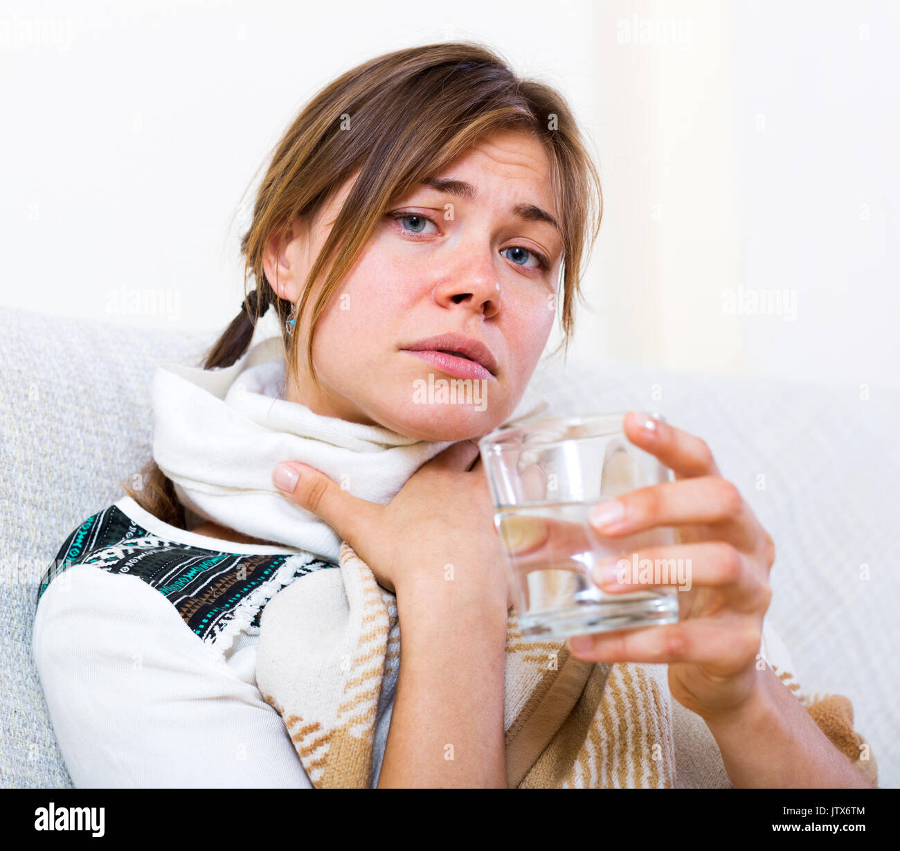 Sad young girl suffering of sore throat and fever at home Stock Photo ...