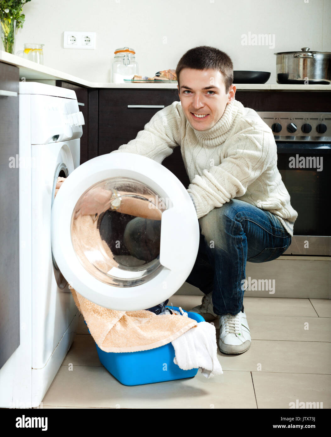 man looking clothes near washing machine Stock Photo - Alamy