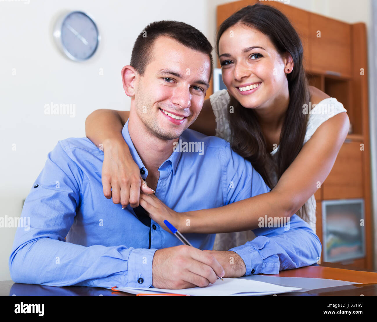 Loving couple filling marriage application form and smiling indoors ...